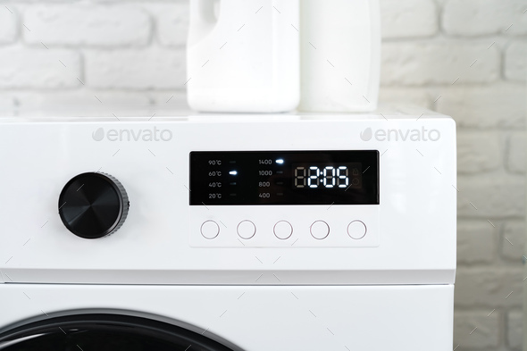 Modern white washing machine in a laundry room Stock Photo by FabrikaPhoto