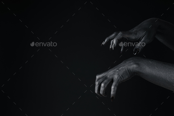 Black female hands with black nails on black background, space for text ...