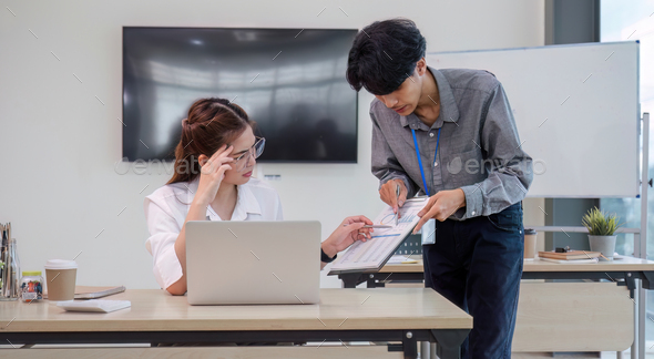 Concentrated male employee explaining meeting minutes to serious ...