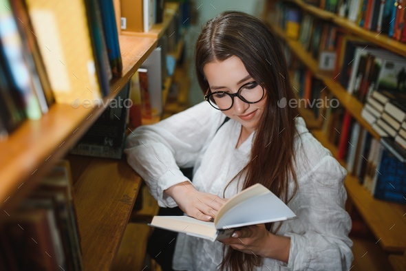 Beautiful girl in a library Stock Photo by sedrik2007 | PhotoDune