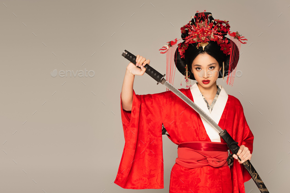 Asian woman taking sword from sheath isolated on grey Stock Photo by ...