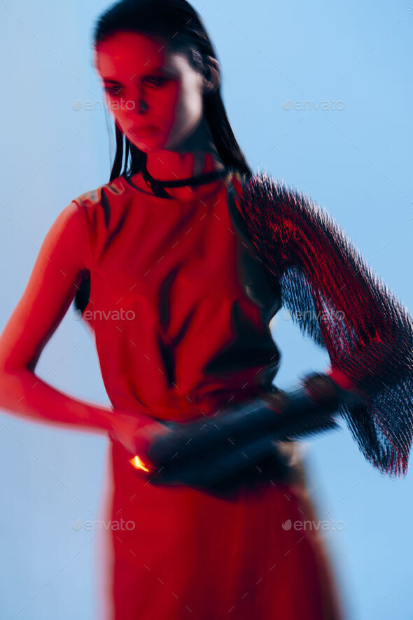attractive woman Glamor posing red light metal armor on hand isolated ...