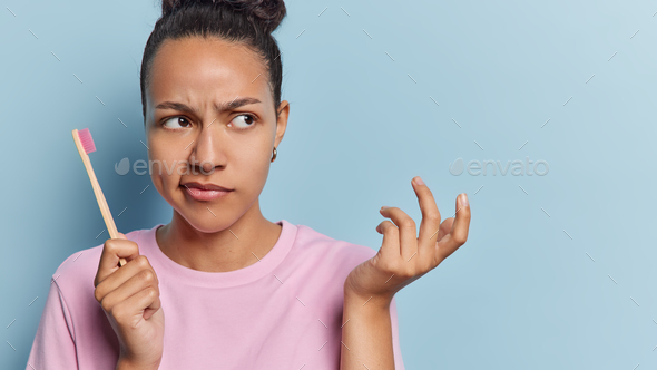 Horizontal shot of confused discontent Latin woman shrugs shoulders ...