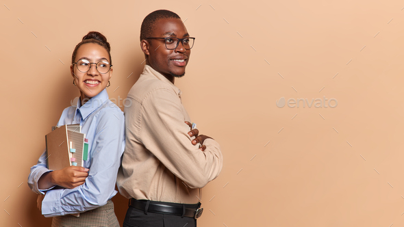 Female and male students stand back to each other carry notepads keen ...