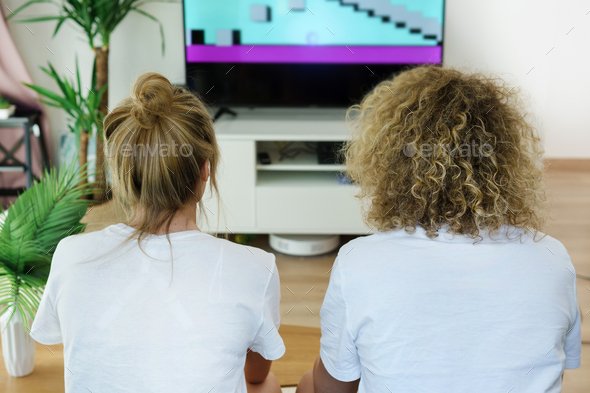 Two beautiful girls playing video game console in a living room Stock ...