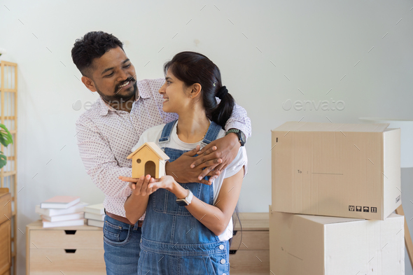 Married Indian couple owners holding house model moving in new home. relocation concept Stock ...