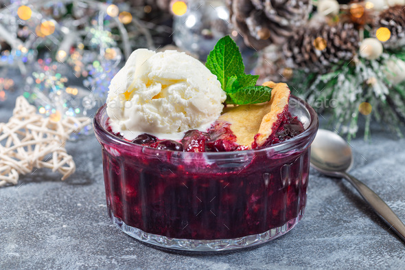 Berry cobbler in glass ramekin with ice cream, Christmas decoration ...