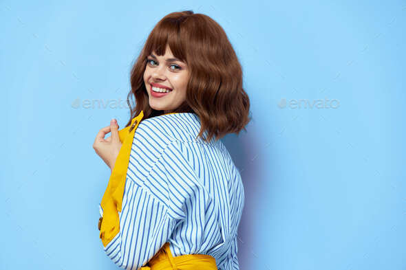 Fashionable woman in striped shirt and in yellow coat model back view ...