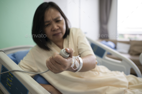 Middle-aged Asian female patient recovering from illness in hospital ...