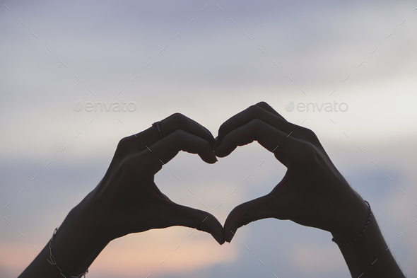 Symbolic of love body language, Heart with hand gesture isolated on sky ...