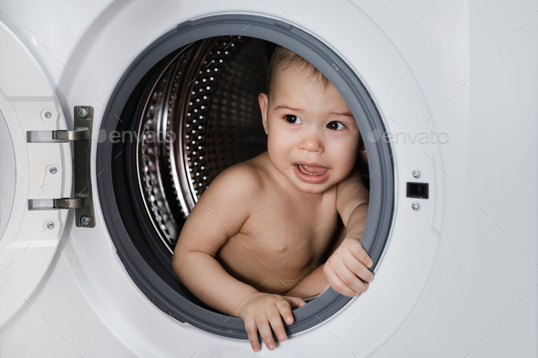 Scared baby boy sitting inside the washing machine Stock Photo by BLACKDAY