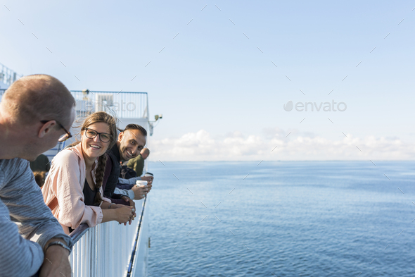 Group of people leaning on railing on ship deck Stock Photo by ...
