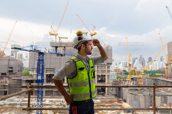 Portrait of an engineer designing a large project inspecting the job ...