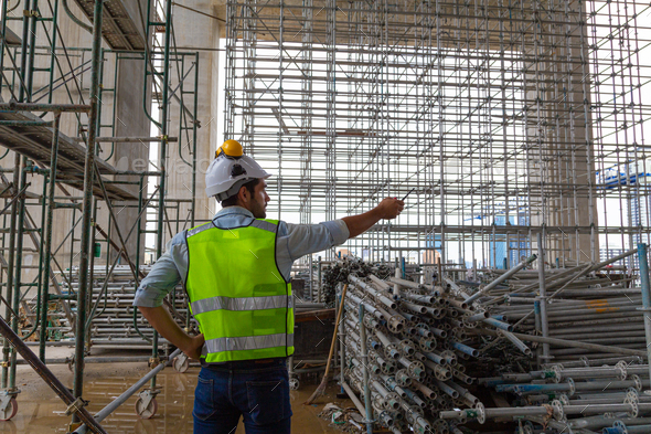 Portrait of an engineer designing a large project inspecting the job ...