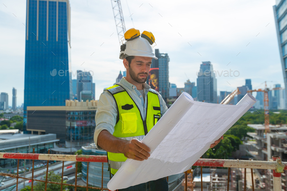architect engineer designing a structure holding tablet, walkie talkie ...
