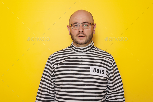 Man wearing prison uniform on yellow colored background Stock Photo by ...