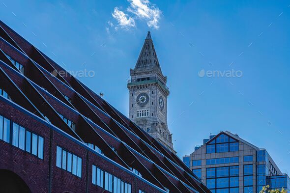 A BRICK CLOCK TOWER WITH A BRICK BUILDING IN FRONT AND A MODERN GLASS ...