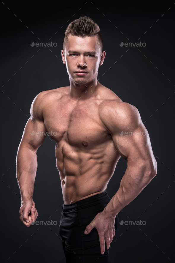 Young bodybuilder is showing his muscles in studio Stock Photo by BLACKDAY