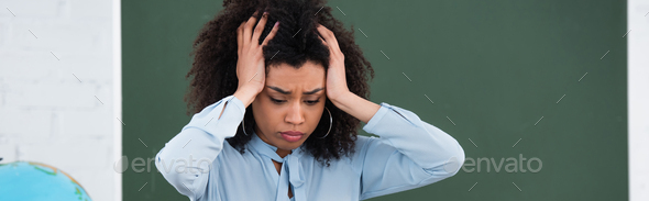 African american teacher having headache near blurred globe in ...