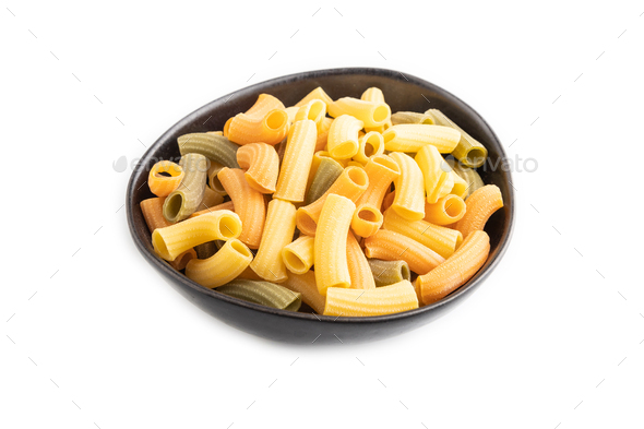 Rigatoni colored raw pasta in bowl isolated on white. Side view. Stock ...