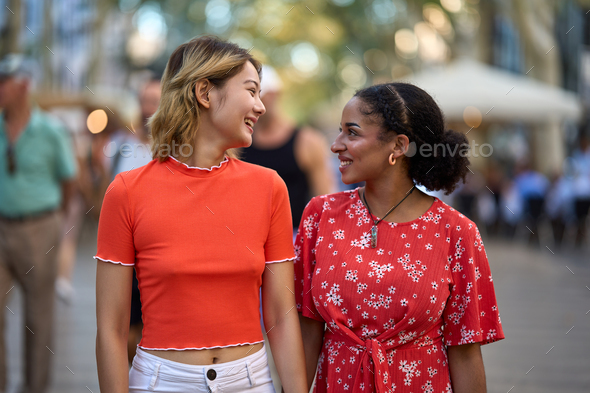 Multi-ethnic couple walking together in a crowded street Stock Photo by ...