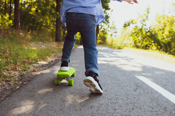 Child boy riding penny board on asphalt road Stock Photo by irinapavlova1
