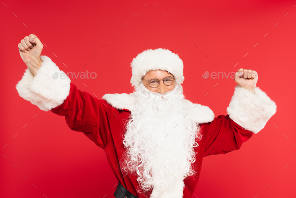 Santa claus in eyeglasses showing yes gesture isolated on red Stock ...