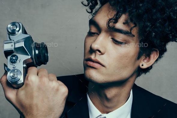 stylish man with camera in hand photography studio curls model portrait ...