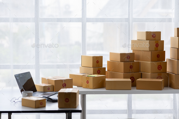 Parcel boxes on shelf and color shopping bags placing near laptop on ...