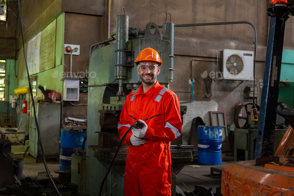 Two engineers in a steel mill Consult the size of the steel workpiece ...