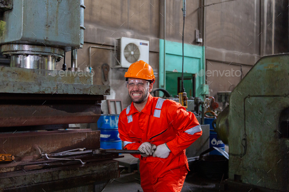 Two engineers in a steel mill Consult the size of the steel workpiece ...