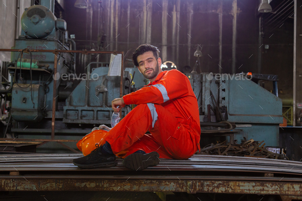 Two engineers in a steel mill Consult the size of the steel workpiece ...