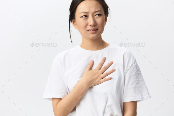 Heart attack. Suffering from pain tanned beautiful young Asian woman ...