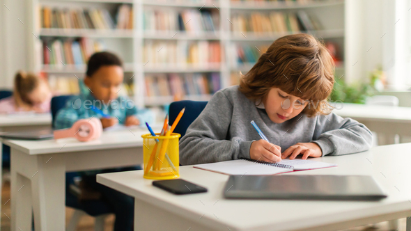 Smart diverse school kids writing in copybooks at desks Stock Photo by ...