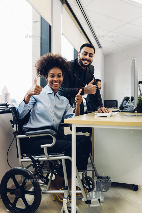 Office workers and woman on a wheelchair in bright office. Stock Photo ...