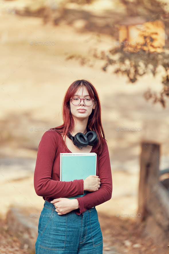 Girl student stands holding notebooks in her hands. School and higher ...