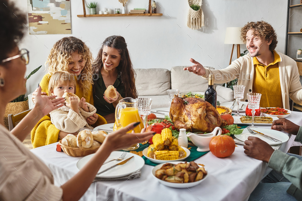 happy multiracial family talking and gesturing during Thanksgiving ...