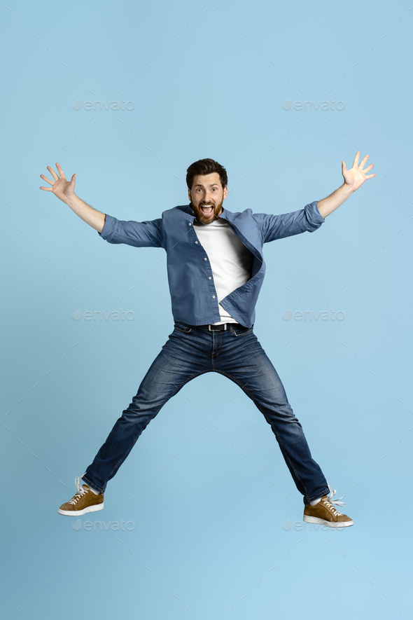 Full length portrait of a handsome emotional bearded man jumping high ...