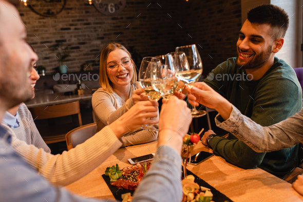 Group of young friends having fun in restaurant, talking and laughing ...
