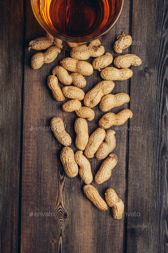 beer mug with peanuts in shells on wooden background pub alcoholic ...