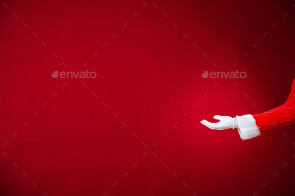 Santa Claus hand reaching out with an open palm on a red background ...