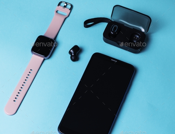 Overhead shot of smart phone, smart watch, wireless earphones case on ...