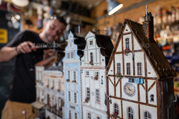 Model maker man working at scale model of miniature building in his ...