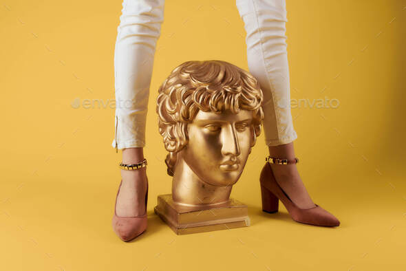 Female feet head sculptures golden color luxury yellow background Stock ...