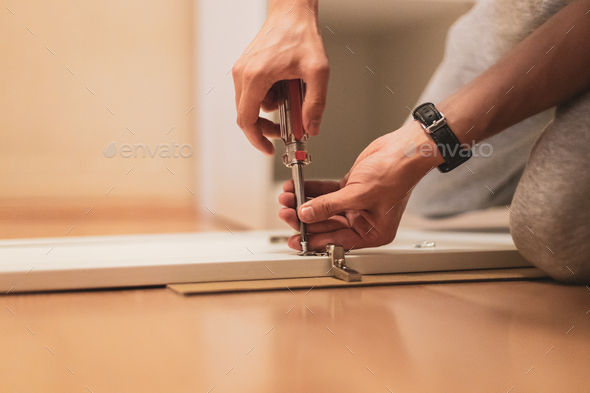 The hands of a young man are twisting a screw with a screwdriver. Stock ...