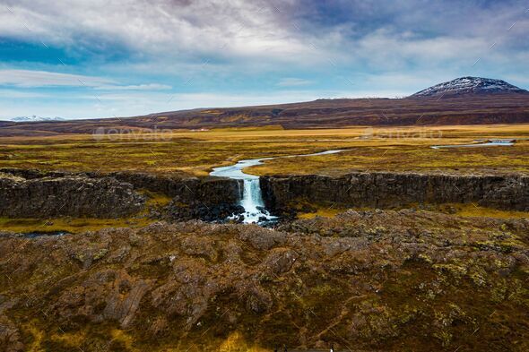 Small waterfall in the Thingvellir National Park under a cloudy sky in ...