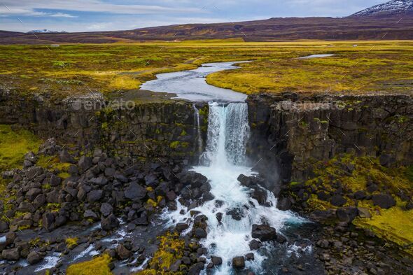 Small waterfall in the Thingvellir National Park under a cloudy sky in ...