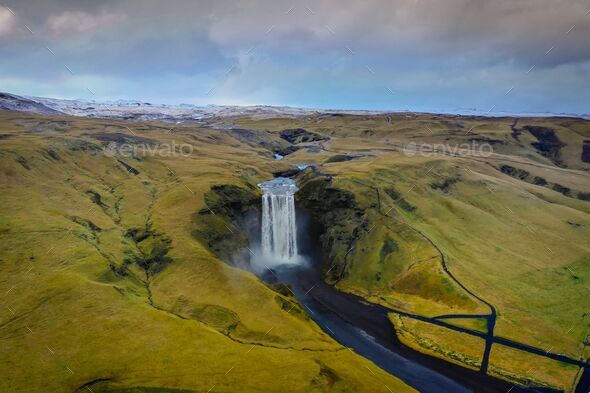 Mesmerizing aerial view of Skogafoss waterfall captured on a cloudy day ...
