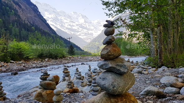 Stacked towers of rocks next to a stream at the end of the ...