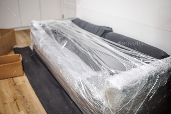 Wrapping sofa in stretch film indoors, closeup Stock Photo by sweet_elenia